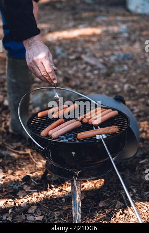Man grill hot dogs in the forest Stock Photo - Alamy