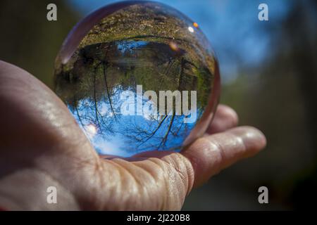 Hand holding glass ball with inverted nature and landscape image Stock ...
