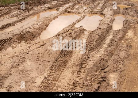 Dirty road. puddle with havy tires track Stock Photo - Alamy