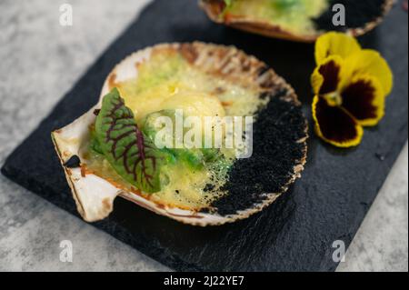 Delicacy roasted scallops with cheese spices and chuka algae Stock ...