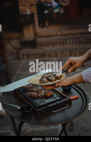 Grill kitchen. Chef uses knife to cut smoked pork ribs Stock Photo - Alamy