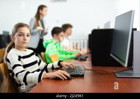 Tween girl during lesson in computer room of school library Stock Photo ...