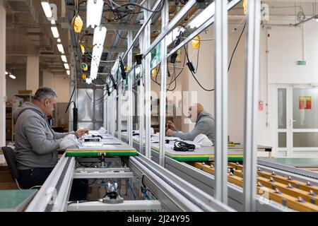 Photo of a plant for assembling monoblocks for computers. Working men ...