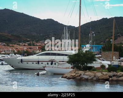 Yachts and sailboats in the port of Budoni. In the background the red ...