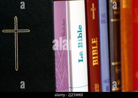 Christian bibles of different versions on a bookshelf. Religious symbol ...