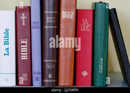 Christian bibles of different versions on a bookshelf. Religious symbol ...