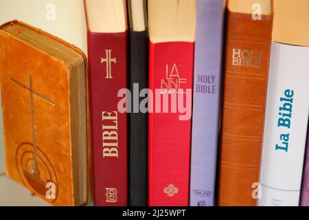 Christian bibles of different versions on a bookshelf. Religious symbol ...