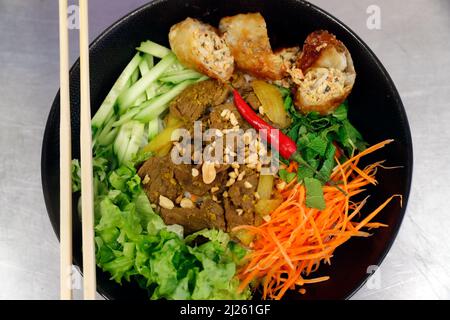 Asian kitchen. Vietnamese cuisine. Bowl of beef Bo bun with salad, beef ...