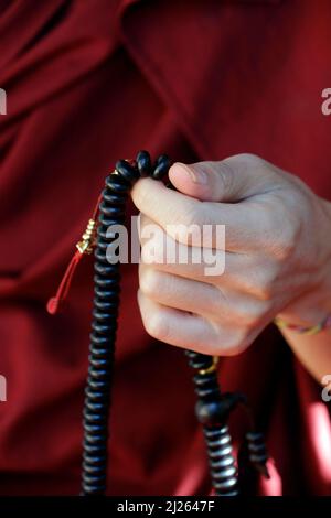 Hand of a monk praying and counting beads at a mala Stock Photo - Alamy