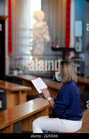 Catholic woman reading a chinese bible Stock Photo - Alamy