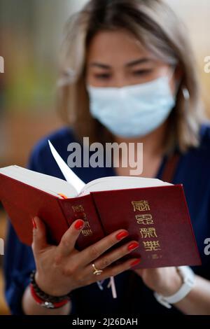 Catholic woman reading a chinese bible Stock Photo - Alamy