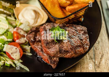 Appetizing overhead shot of juicy grilled beef steak slices served with ...