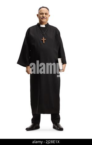 Portrait of a catholic priest holding the bible. Black background Stock ...