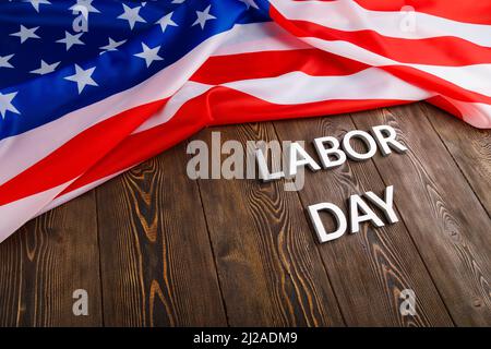 words labor day laid with silver metal letters on wooden surface with ...