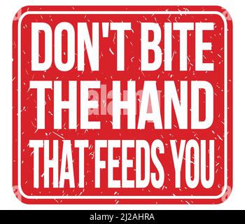 DON'T BITE THE HAND THAT FEEDS YOU, written on red grungy stamp sign ...