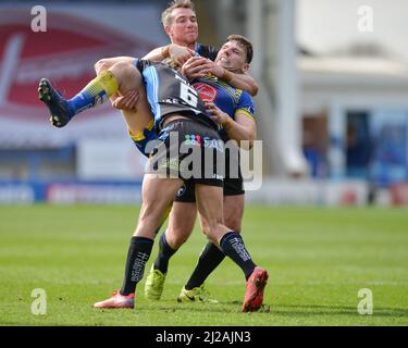 George Williams #7 of Warrington Wolves is tackled by Jacob Miller (6 ...