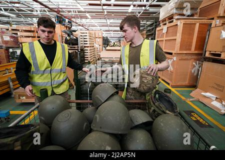 Members of the military pack thousands of surplus helmets donated by ...
