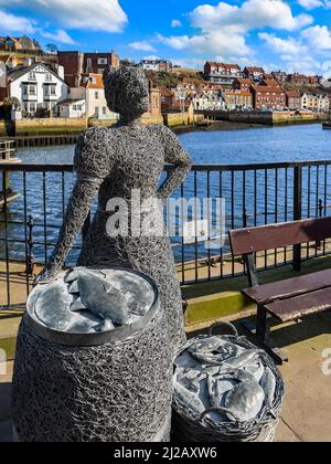 Wire statue of a fishwife at the harbor in the port of Whitby on the ...