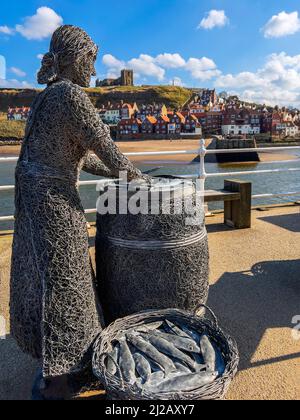 Wire statue of a fishwife at the harbor in the port of Whitby on the ...