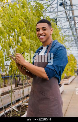 woman in greenhouse writing on a board Stock Photo - Alamy
