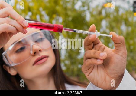 African american botanist holding syringe near cauliflower and ...