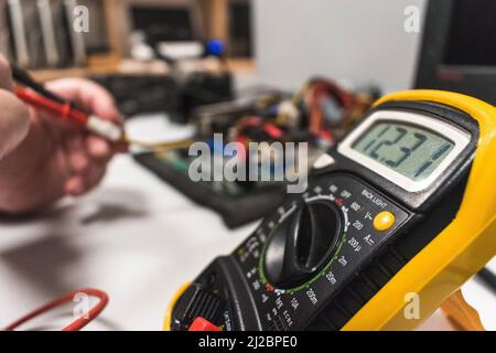 Detail of a multimeter being used by a technical IT on a computer ...