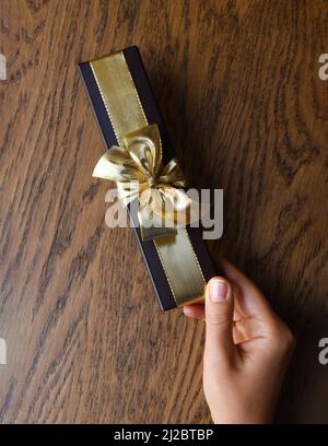 Brown Gift Box on hand for Christmas concept with yellow blur bokeh ...