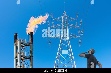 Industrial gas flare stack/chimney and electricity pylon. Rising energy ...