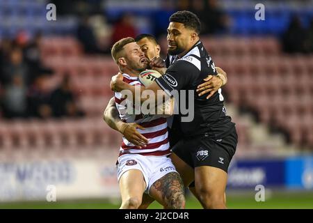 Zak Hardaker of Hull FC is tackled by Max Jowitt of Wakefield Trinity ...