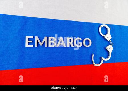 the word embargo laid with silver metal letters on russian tricolor ...