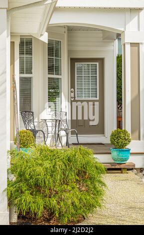 Porch and entrance of a nice residential house with two flower pots ...