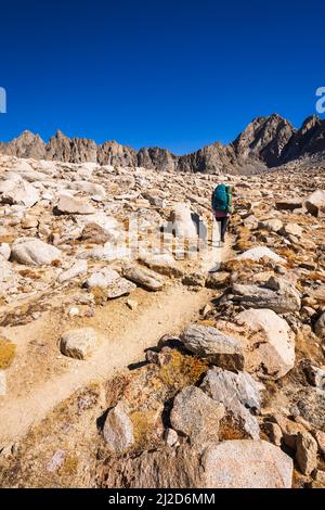 Backpacker crossing Bishop Pass, Kings Canyon National Park, California ...