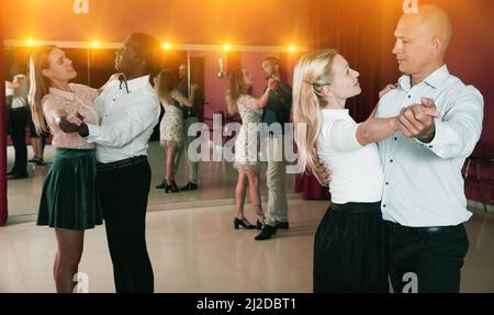 Positive people learning to dance waltz together in dancing class Stock ...
