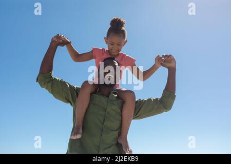 low angle view of happy african american man holding coffee to go near ...
