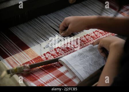 An Assamese woman weaves Assamese Traditional Gamosa (scarf) in ...