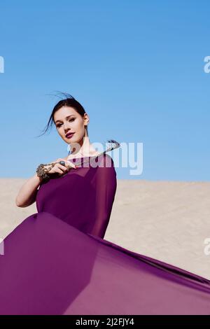Young Indian female in a purple traditional dress using a smartphone ...