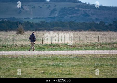 man walking at speed along an unmade track road, hiking, fitness Stock ...