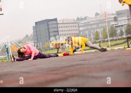 Amazing and strong friends are stretching together on the ground and ...