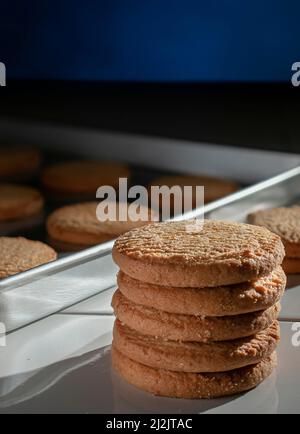 a pile of cookies with a glass of ice milka in a kitchen tray in a dark ...