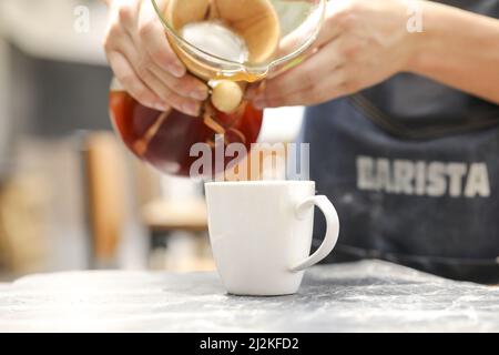 A closeup of a Chemex Coffeemaker near a white cup Stock Photo - Alamy