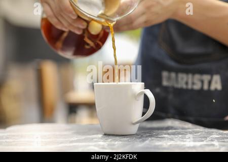 A closeup of a Chemex Coffeemaker near a white cup Stock Photo - Alamy