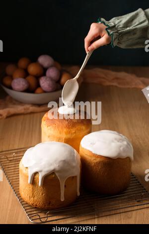 A girl smears Easter cakes with icing, photo in a rustic style Stock ...