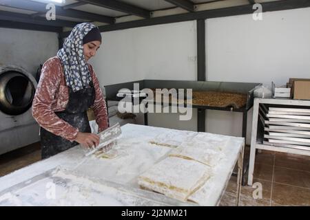 A Palestinian woman prepares sweet (halqum), an Iraqi-Turkish dessert ...