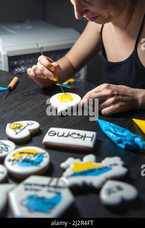 Preparation of handmade gingerbread with symbols of Ukraine, icing ...