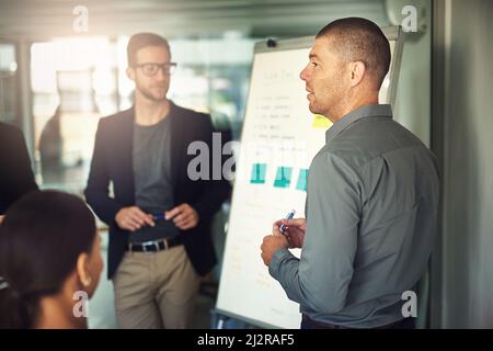 Coming up with a plan of action. colleagues having a meeting in an ...