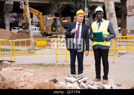 Architect tells engineer where to dig a trench to lay pipe Stock Photo ...