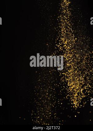 A stream of fragrant spices in frozen flight on a black background ...