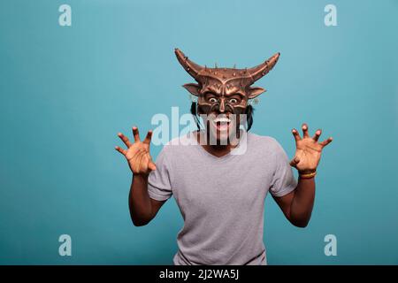 Young man wearing ancient tribal mask with sacral pattern and design ...