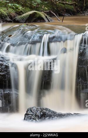 A vertical shot of a small waterfall in Aroser Weisshorn mountains ...