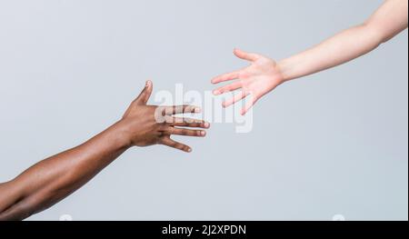 Helping hands, Rescue gesture. African and caucasian hands. Giving a ...